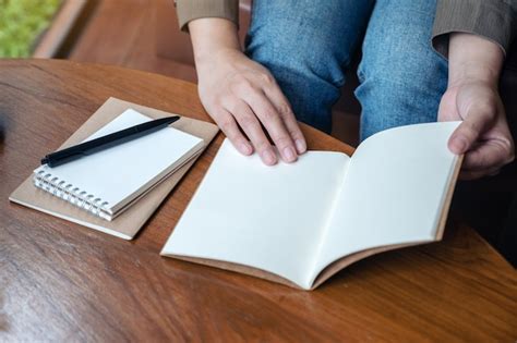 Premium Photo Woman Opening A Notebooks On Wooden Table
