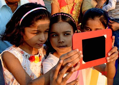 Patna Girls Try To See A Partial Solar Eclipse In The Sky Through An