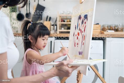 아시아 의 젊은 행복한 아이 딸 어머니와 함께 그림 보드에 착색 행복한 가족 활동 어린 소녀 아이는 수채화 페인트와 브러시와