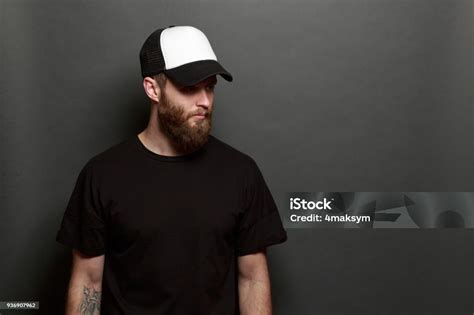 캐주얼 도시 스타일에 블랙 빈 T셔츠와 귀하의 로고 또는 디자인에 대 한 공간을 가진 검은 야구 모자를 입고 수염과 Hipster 잘생긴 남성 모델 T 셔츠에 대한 스톡