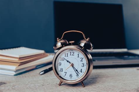 Premium Photo Laptop Clock And Notebook On Table