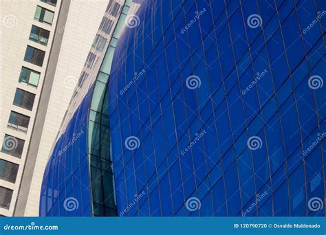 Close Shot Of A Modern Curved Blue Glass Window Wall Next To A