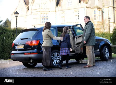 A Security Guard Provides Close Protection While A Mother Collects Her