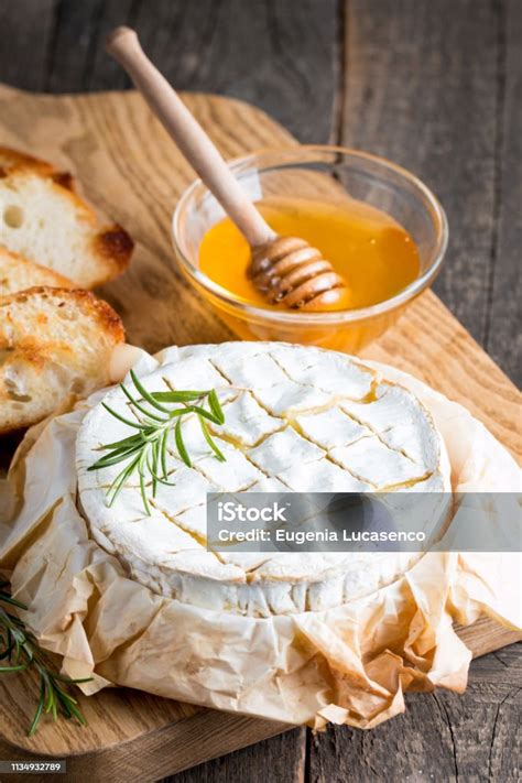 카망트 치즈를 구운 신선한 브리 치즈와 견과류 꿀 로즈마리 바게트 빵 토스트와 나뭇잎 나무 보드에 슬라이스 치즈의 브리 타입 이탈리아어 프랑스 치즈 오븐 구이에 대한 스톡