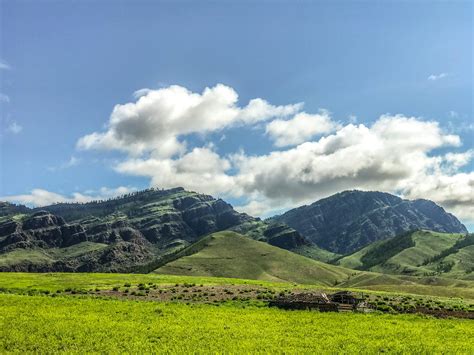 푸른 잔디 밭과 낮에는 흰 구름과 푸른 하늘 아래 산 사진 Unsplash의 무료 몽골 이미지