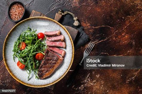 야채 샐러드와 접시에 구운 최고 등심 쇠고기 고기 스테이크 어두운 배경 맨 위 보기입니다 복사 공간 검은색에 대한 스톡 사진 및 기타 이미지 Istock