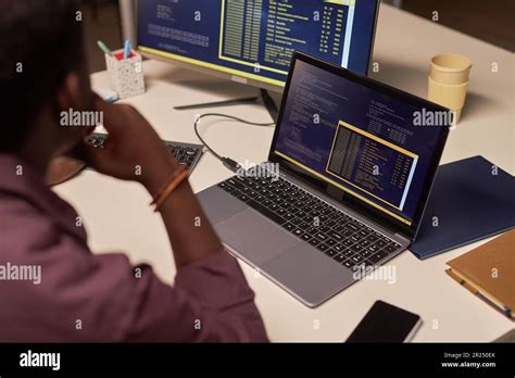 Rear View Of African American Developer Typing Computer Codes On Laptop