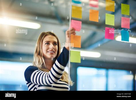 In Brainstorming Mode A Young Woman Having A Brainstorming Session With Sticky Notes At Work
