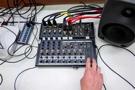 Sound Engineer Working On Audio Mixing Console With Cables Connected