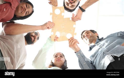 Group Of Business People Assembling Jigsaw Puzzle And Represent Team