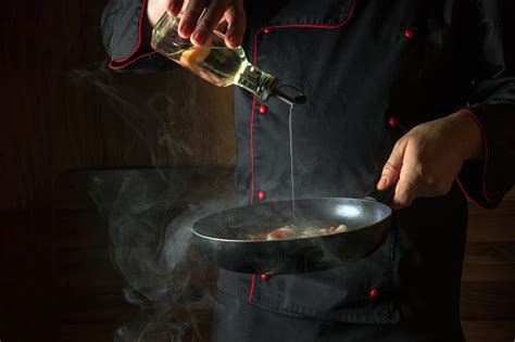 요리사는 프라이팬에 튀긴 당근과 양파에 올리브 오일을 첨가합니다 점심 야채 요리 어두운 배경에 레스토랑 또는 호텔 메뉴 건강한 생활방식에 대한 스톡 사진 및 기타 이미지