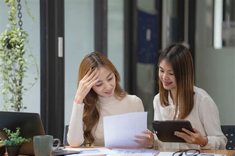 두 명의 젊은 아시아 여성 사업가가 새로운 스타트업 프로젝트 아이디어 프레젠테이션을 통해 이야기하고 상담하고 토론하고 사무실에서