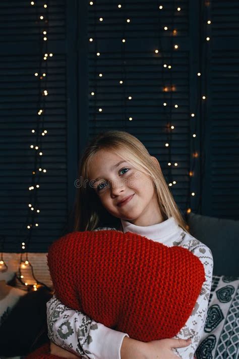 Девушка обнимая красную подушку на зимний день Стоковое Изображение изображение насчитывающей