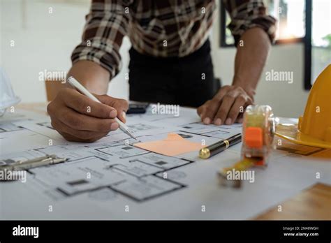 Architect Working In Office With Blueprints Engineer Inspect Architectural Plan Sketching A