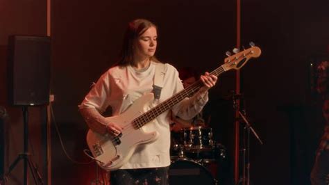 Focused Young Girl Playing Bass Guitar Accompanied By Drummer In Music
