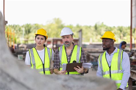 프리캐스트 공장 현장에서 프로젝트를 점검하는 엔지니어 및 감독 작업자 팀 건설 현장에서 논의하는 안전모를 쓴 엔지니어 및 건축업자 3 명에 대한 스톡 사진 및 기타 이미지