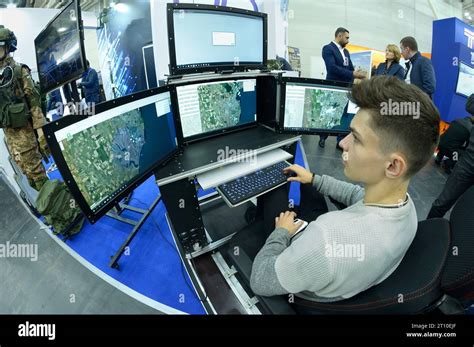 Young Man Sitting In Front Of Monitors And Working With Military