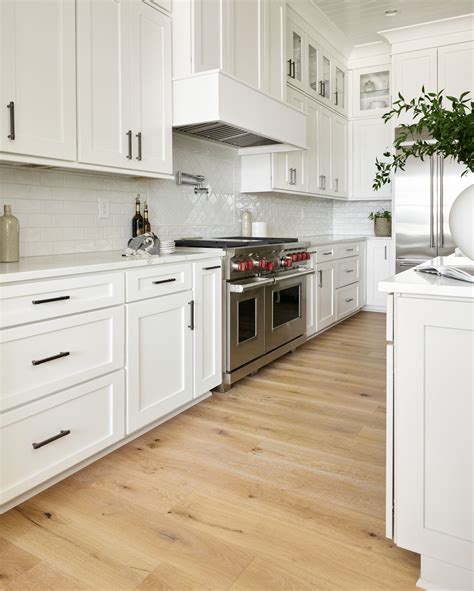 White Kitchen Cabinets Paired With Light Hardwood Floors Kitchen