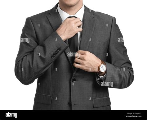 Handsome Man In Formal Suit Adjusting Tie On White Background Closeup