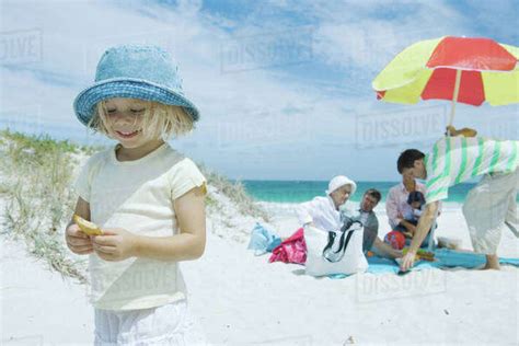 Preteen Girl Sitting On Beach With Barefeet Hugging Knees Stock