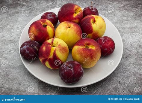 Plums And Peaches In A Clear Dish Isolated On Granite Background Stock
