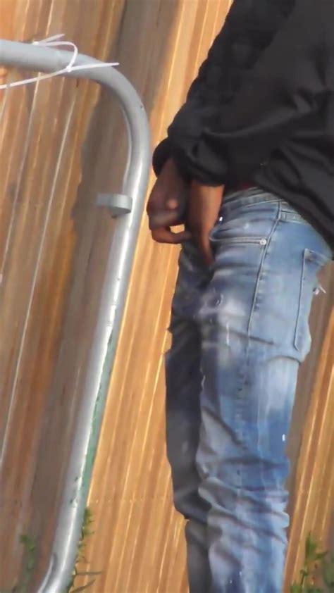 Guys Pissing Against A Fence