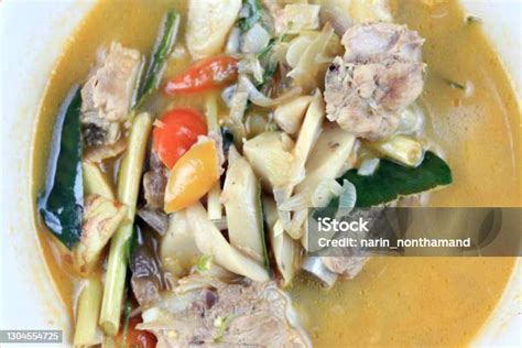 매운 삶은 돼지 고기 뼈와 짚 버섯 야생 토마토 나무 테이블에 흰색 그릇에 톰 얌 수프에 허브 태국 스타일의 음식에 톰 얌 수프 돼지 고기 0명에 대한 스톡 사진 및 기타