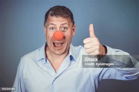 파란 셔츠를 입은 중년 남성과 파란색 배경을 배경으로 포즈를 취하는 빨간 광대 코 40 44세에 대한 스톡 사진 및 기타 이미지