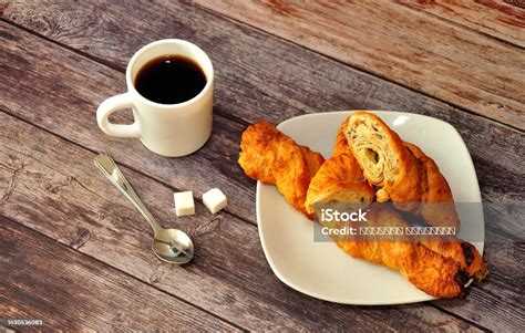 두 개의 퍼프 패스트리와 나무 테이블에 두 개의 설탕 큐브가있는 뜨거운 검은 커피 한 잔이있는 접시 가정의 방에 대한 스톡 사진 및 기타 이미지 Istock