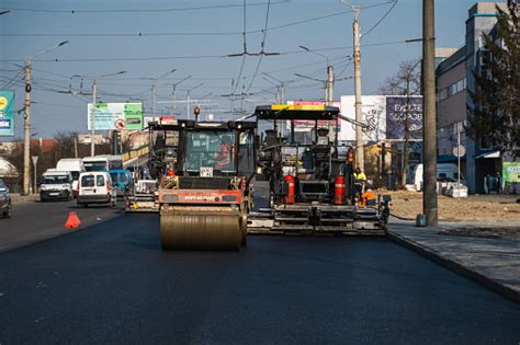 무거운 아스팔트 로드 롤러 무거운 진동 롤러 압축기는 거리의 도로 건설 현장에서 새로운 뜨거운 아스팔트와 아스팔트 파버 기계를 누릅니다 거리에 대한 스톡 사진 및 기타