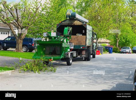 Tree Chipping Company Truck With Tree Chipper On The Job During