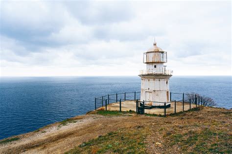 등대는 해안가에 위치한 흐린 하늘 아래 광활한 바다가 내려다보이는 절벽 위에 서 있습니다 0명에 대한 스톡 사진 및 기타 이미지 0명 감시 거친 Istock