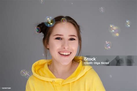 밝은 회색 방에서 비누 거품 중 노란색 후드에 행복한 갈색 머리 여자 행복한 사람들 밀레니엄 세대 유행 십대 트렌디 한 색상 갈색 머리에 대한 스톡 사진 및 기타 이미지