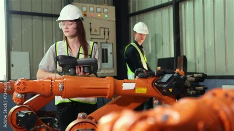 Female And Male Electricians Inspect Analog Remote Control Welding Robot Test Electronic