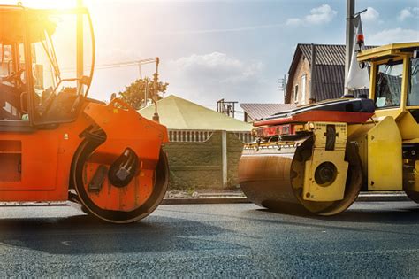 아스팔트 히그웨이 도로 건설 현장 도로 공사와 푸른 하늘 백라운드에서 무거운 산업 기계 증기 로드 롤러 Paver 기계 및 티퍼 덤프 트럭 새로운 포장을위한 뜨거운 역청을