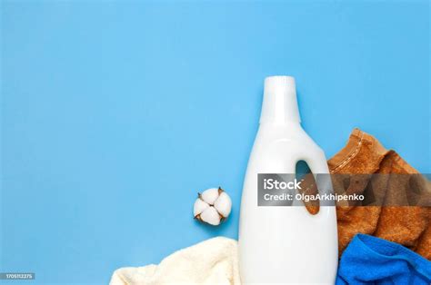 세탁 세제 액체 분말 세척 컨디셔너 수건 및 파란색 배경에 면 꽃의 흰색 플라스틱 포장 플랫 레이 상단 뷰 복사 공간입니다