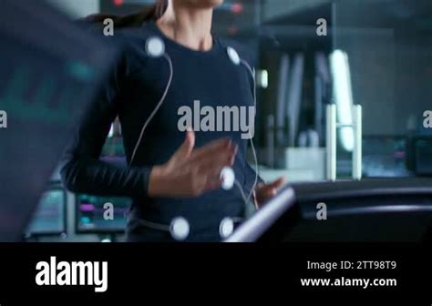 Beautiful Woman Athlete Walks On A Treadmill With Electrodes Attached To Her Body While