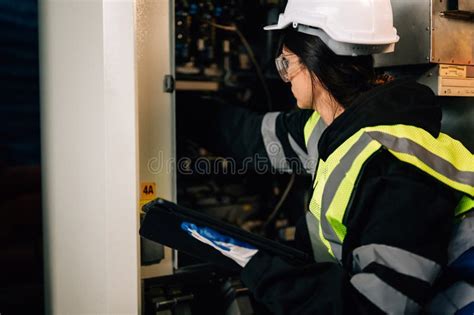 Female Technician Engineer Using Controller Checking Robotic Machine