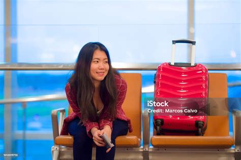 젊고 아름 다운 여자 행복 아시아 한국 관광 여행 출발 비행 명랑 지주 여권 미소를 기다리는에 앉아 공항에서 가방 및 보 딩 패스에 휴일 여행 게이트에 대한 스톡 사진 및