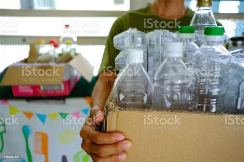 폐기물 제로 지속 가능성 개념 재활용할 플라스틱 병 용기의 갈색 판지 상자를 들고 있는 남자 Hdb 아파트 아파트 외부 배경에 분류되지 않은 재활용 상자 가방에 대한 스톡