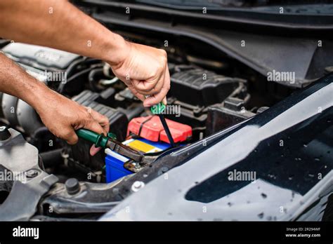 Closeup The Hands Of A Male Technician Are Using A Tool To Replace The Car Battery Parked At