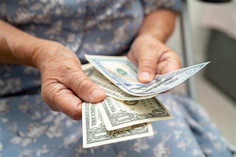 Premium Photo Asian Senior Woman Holding And Counting Us Dollar