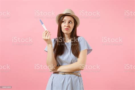 파란 드레스에 슬픈 불행 한 여자 모자 잡고 손 임신 테스트 분홍색 바탕에 고립 된 보고 의료 의료 부인과 임신 임신 출산 사람들 개념 공간에 복사 합니다 건강 진단에 대한