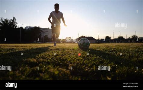 Silhouette Of Sportsman Shooting A Penalty Kicks On Stadium At Sunset