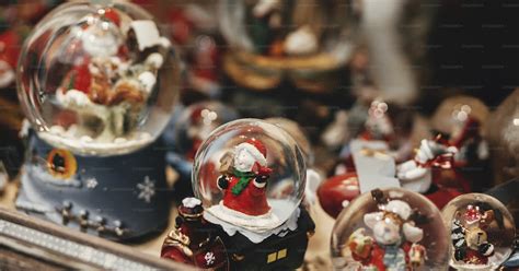 창가에 있는 세련된 크리스마스 스노우 글로브 겨울 방학을 위한 유럽 도시 거리의 크리스마스 축제 거리 장식 마법의 작은 크리스마스 장면 휴일 겨울 박람회 즐거운