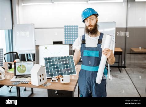 Portrait Of A Dedicated Worker In Workwear With Blueprints And Solar Panel At The Alternative