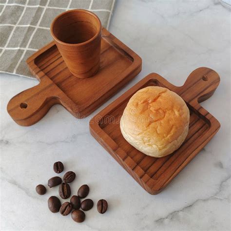 Glass And Bread On Teak Wood Stand On White Table With Coffee Beans Classic Vibes Stock Image