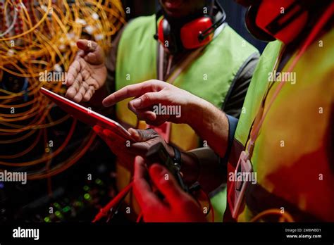 Low Angle Portrait Of Two Technicians Using Tablet While Repairing