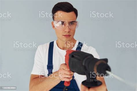 보호 안경과 드릴로 손에 흰색 배경에 대한 스튜디오 의 내부에 서 파란색 유니폼에 남성 노동자 20 24세에 대한 스톡 사진 및 기타 이미지 Istock