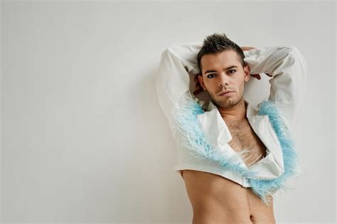 Premium Photo Waist Up Portrait Of Sensual Non Binary Man Leaning On White Wall And Looking At